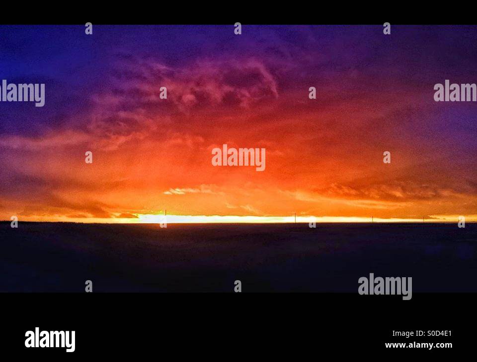 A photo of a sunset taken during a storm during which half the sky was ...