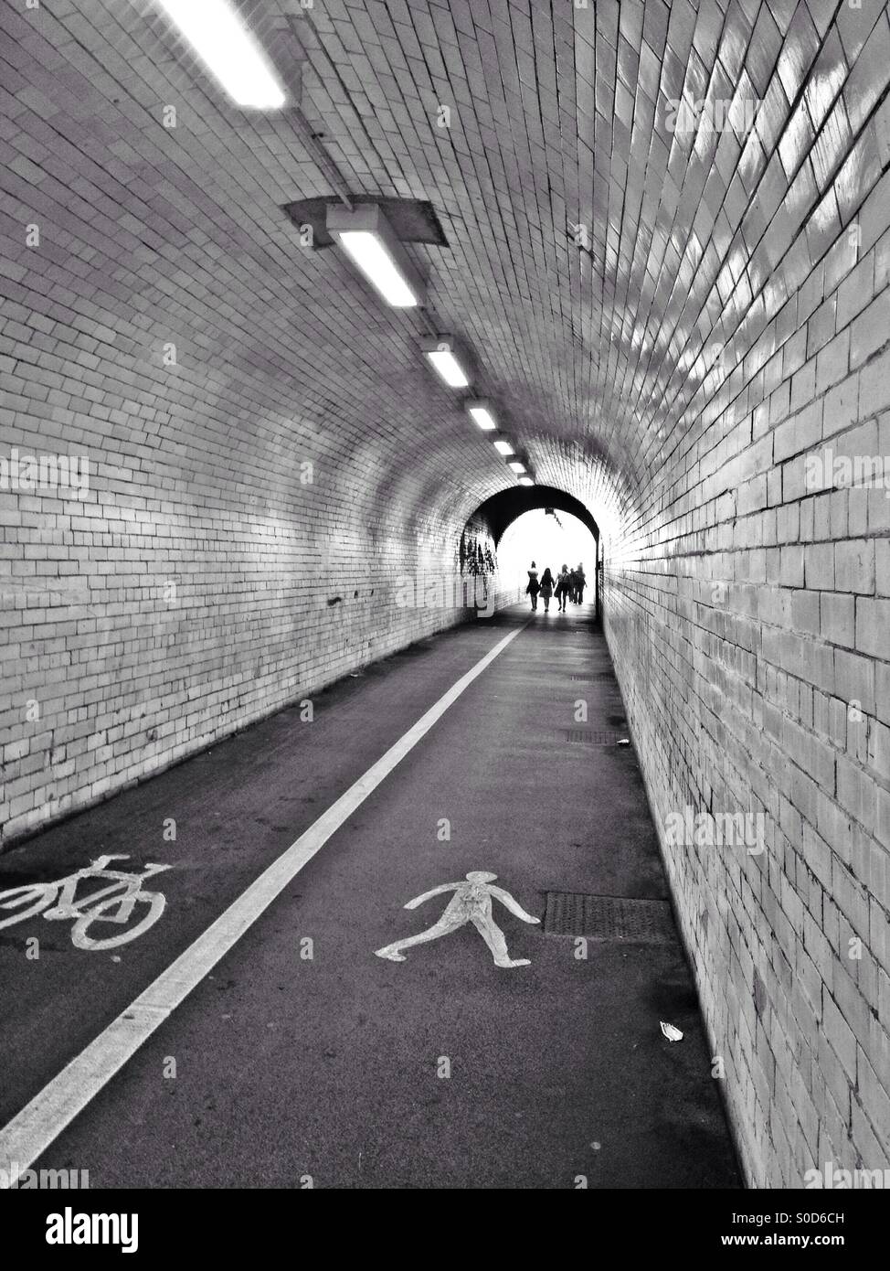 Silhouetted figures in walkway Stock Photo - Alamy