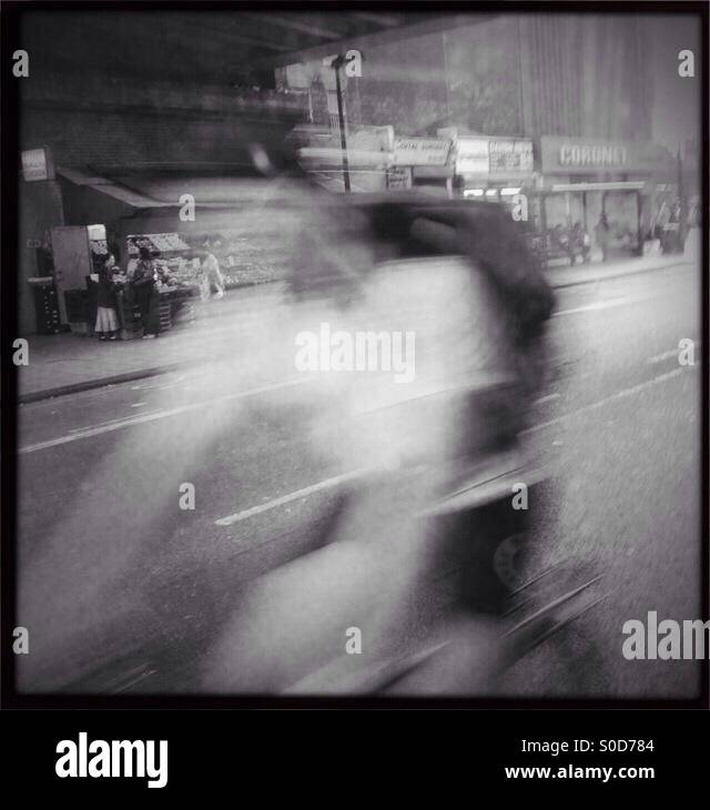 Bike rider cycling past fast blur Stock Photo - Alamy