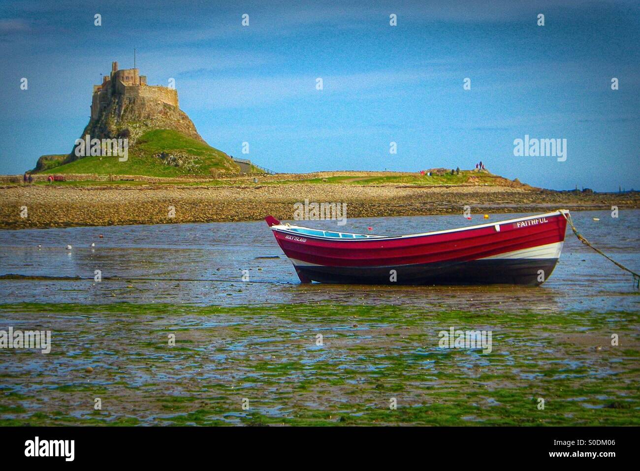 Holy isle and a fishing boat with Lindisfarne castle Stock Photo - Alamy