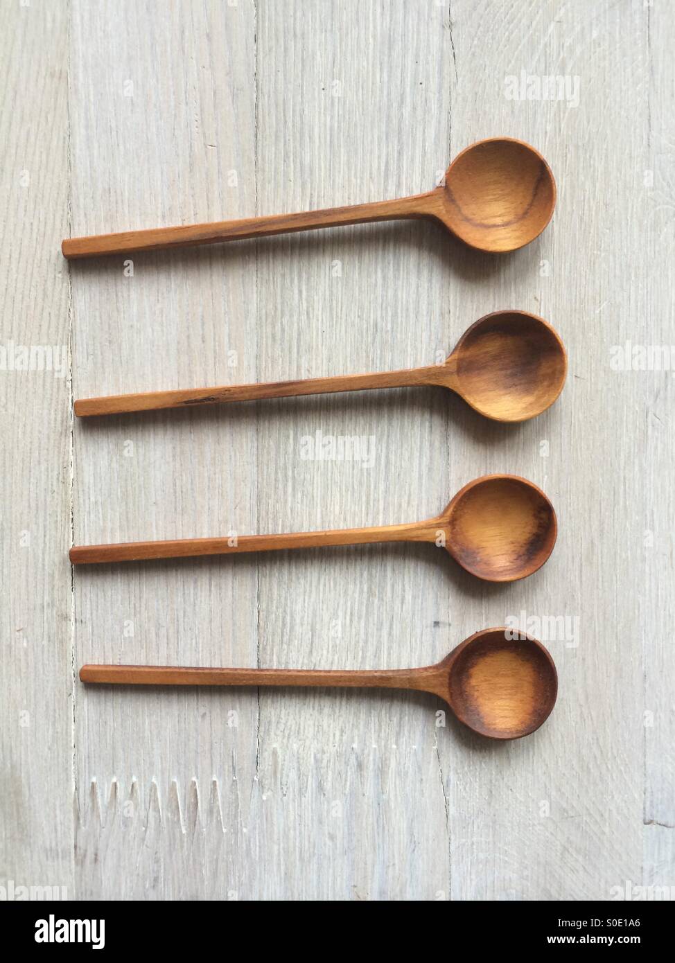 Four wooden spoons in a row Stock Photo - Alamy