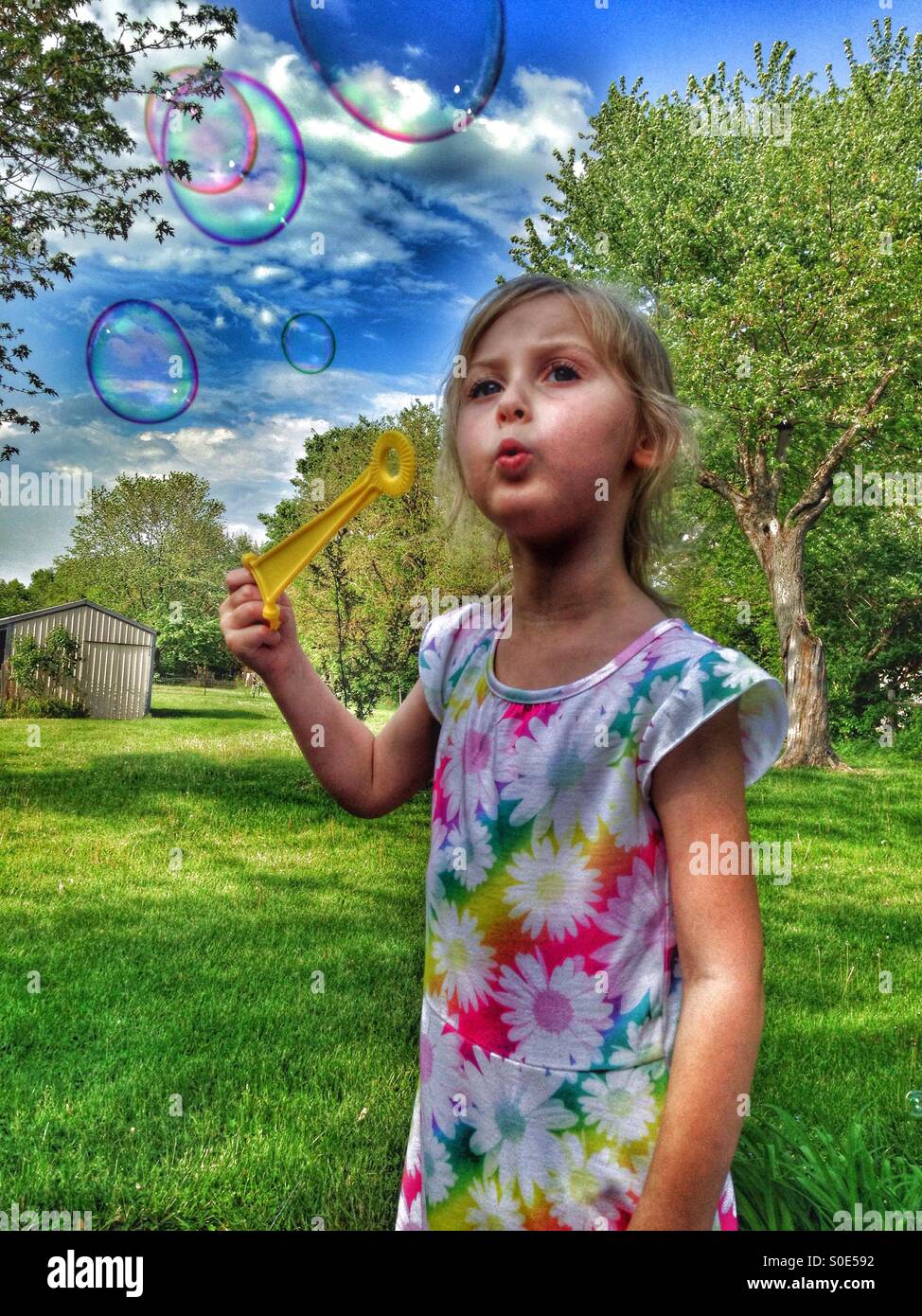 A little girl watches bubbles blow away (1 Stock Photo - Alamy