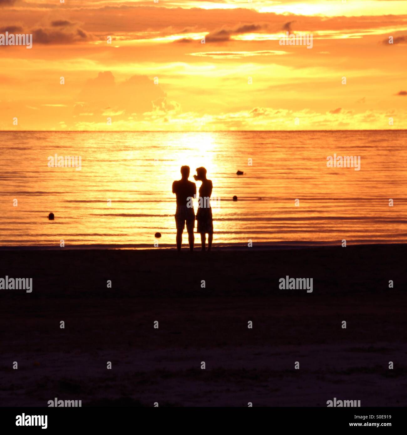 Two people watching the sunset Stock Photo - Alamy