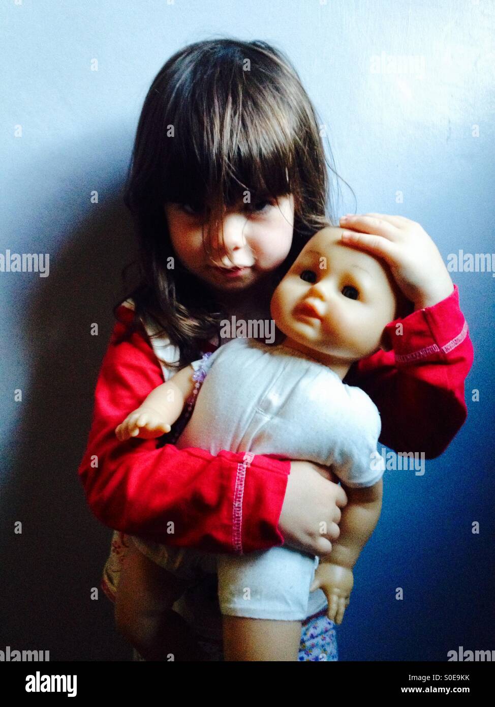 Young girl holding doll Stock Photo - Alamy