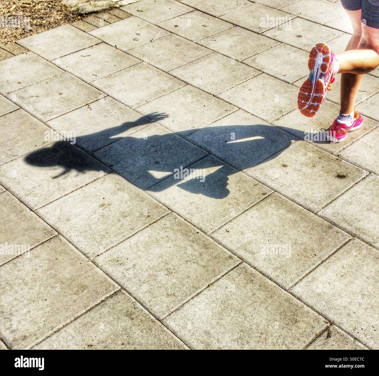 A shadow of an athlete running on the street Stock Photo - Alamy