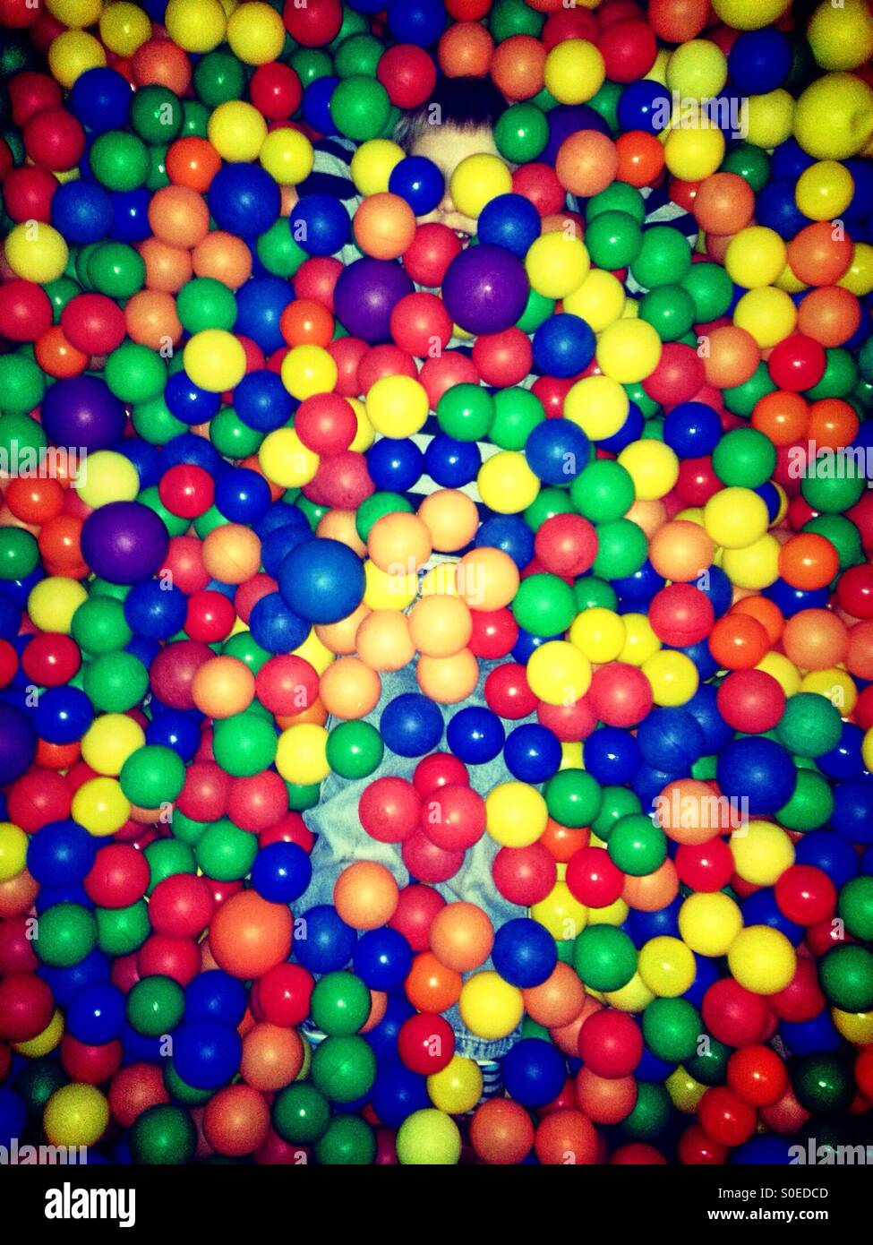 Young Boy Playing in Ball pit Stock Photo - Alamy