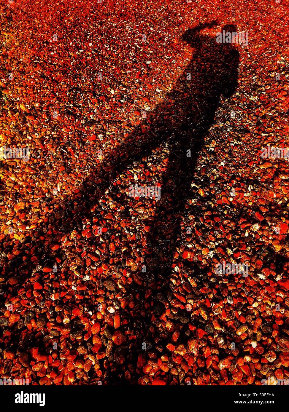 Shadow on pebble beach Brighton Stock Photo - Alamy