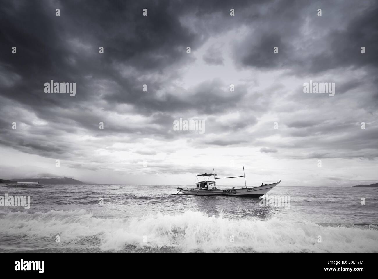 Fishing boat arriving at the shore Stock Photo - Alamy