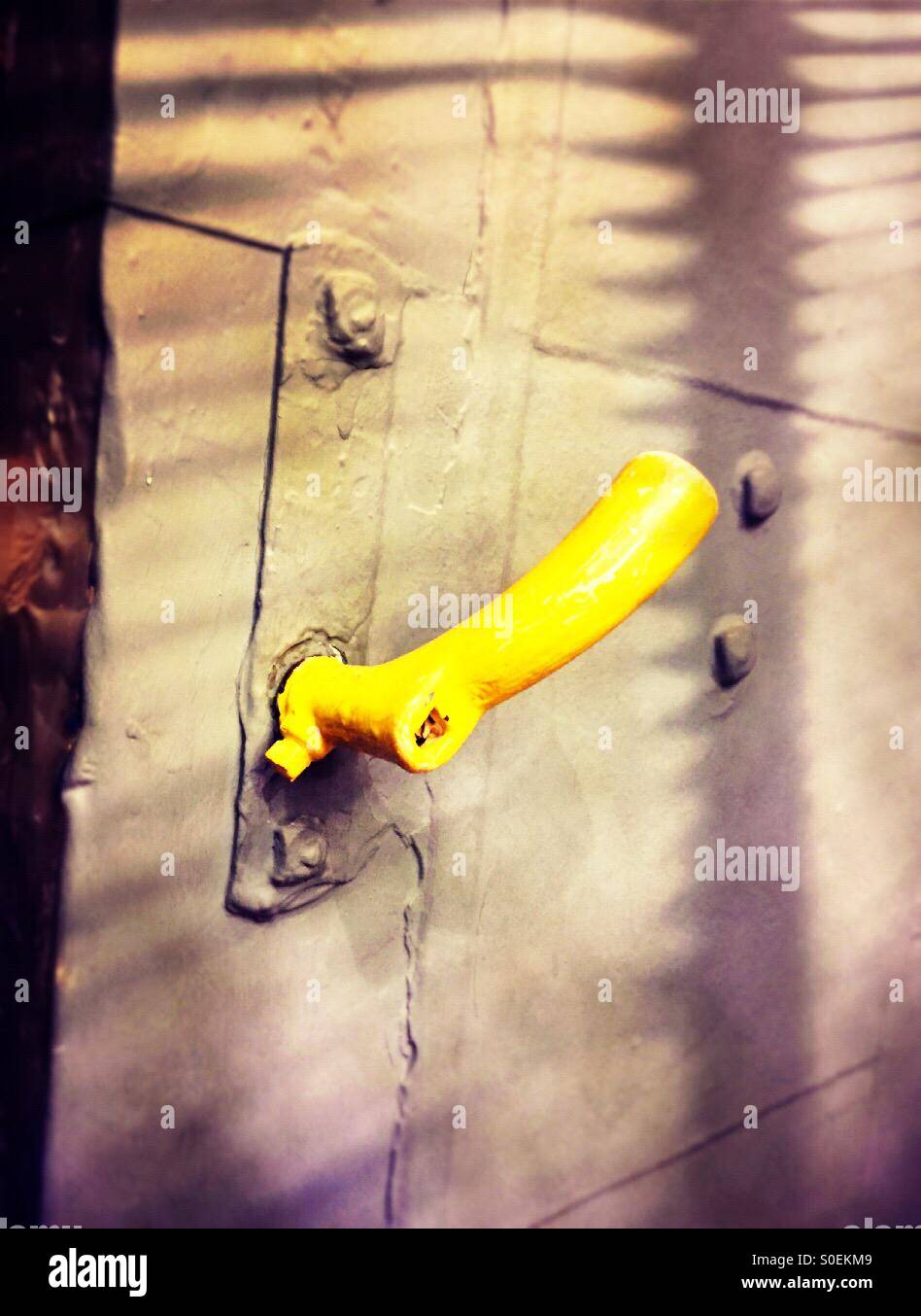 Door with bright yellow lever handle Stock Photo - Alamy