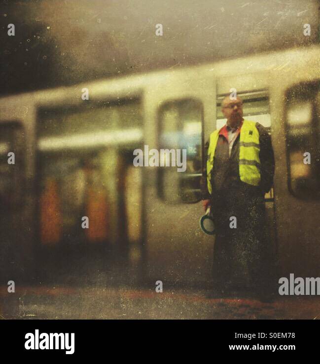 Signal man standing in front of a open metro wagon in a subway station ...