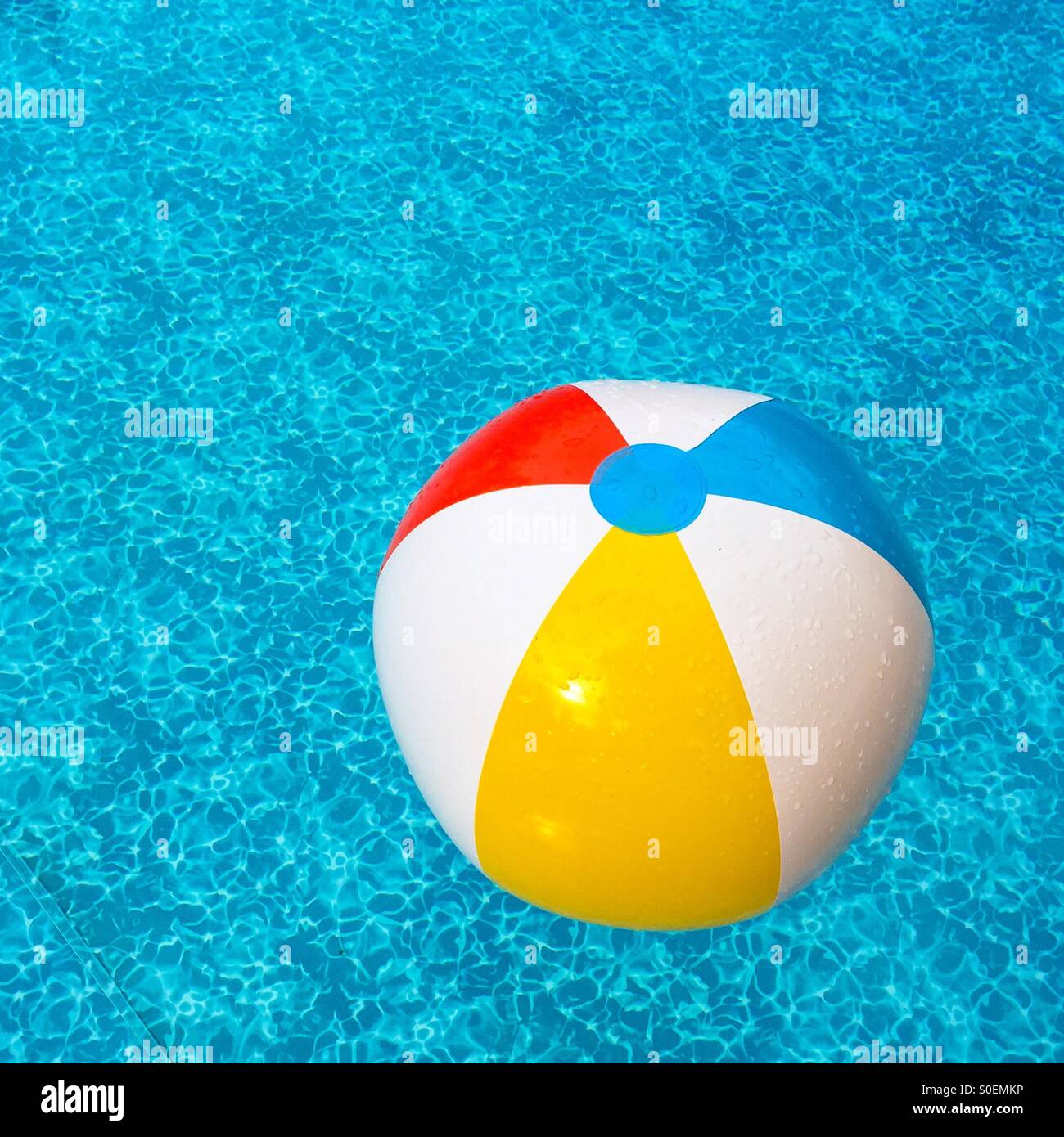 Beach ball in outdoor pool. (Yellow side dominant Stock Photo - Alamy