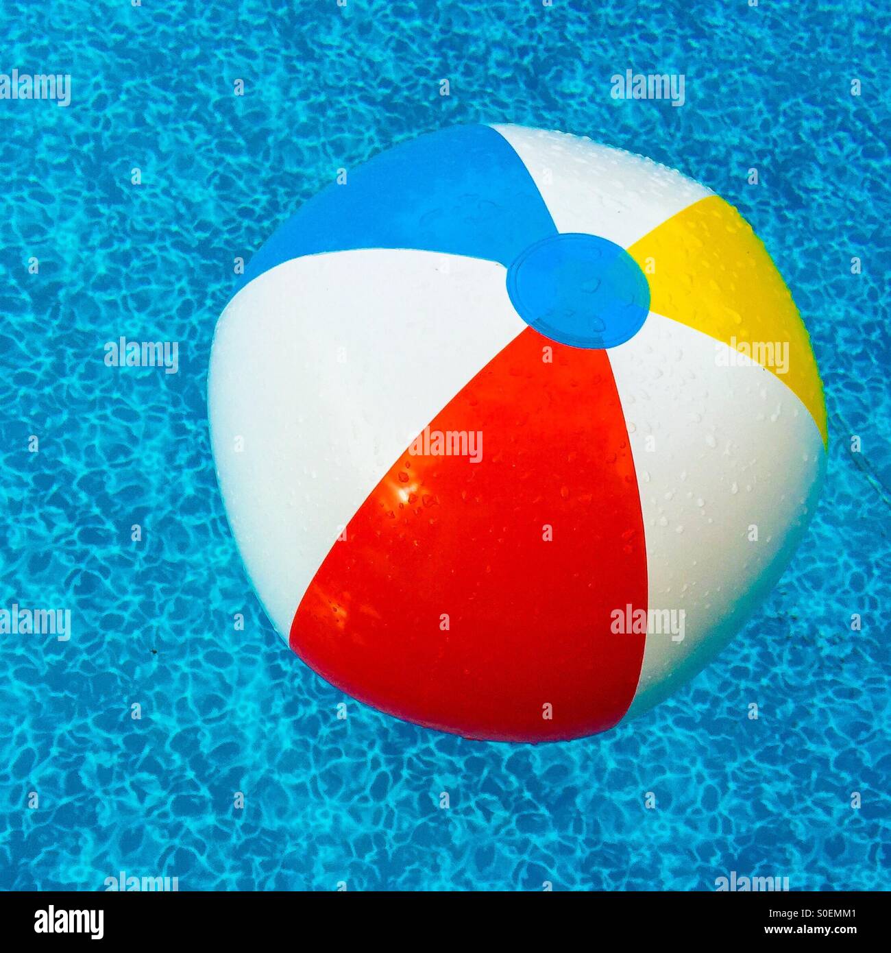 Beach ball in blue waters of swimming pool. (Red side dominant Stock ...