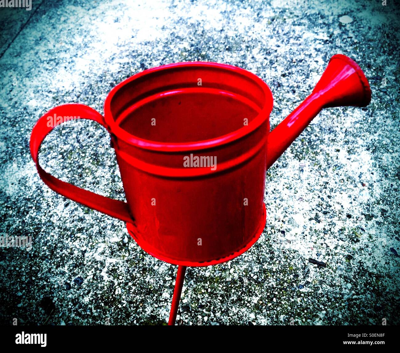 Red watering can on a stick Stock Photo - Alamy