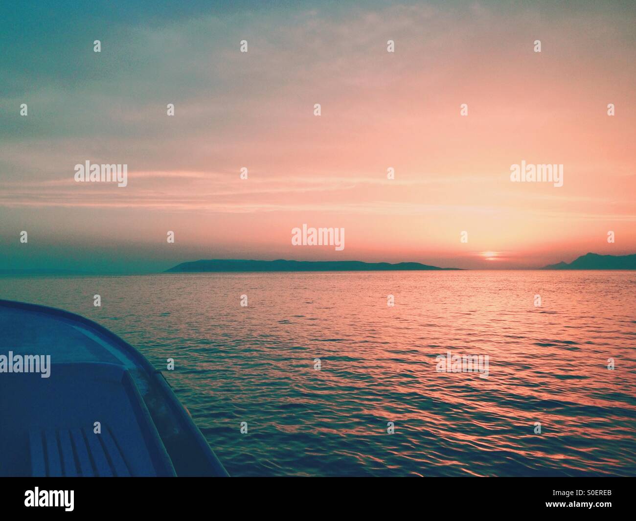 Old wooden boat driving in sunset Stock Photo - Alamy