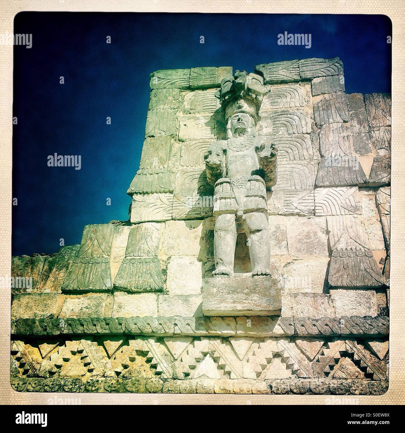 A sculpture of a winged Mayan wearing a mask of an owl decorates a wall ...