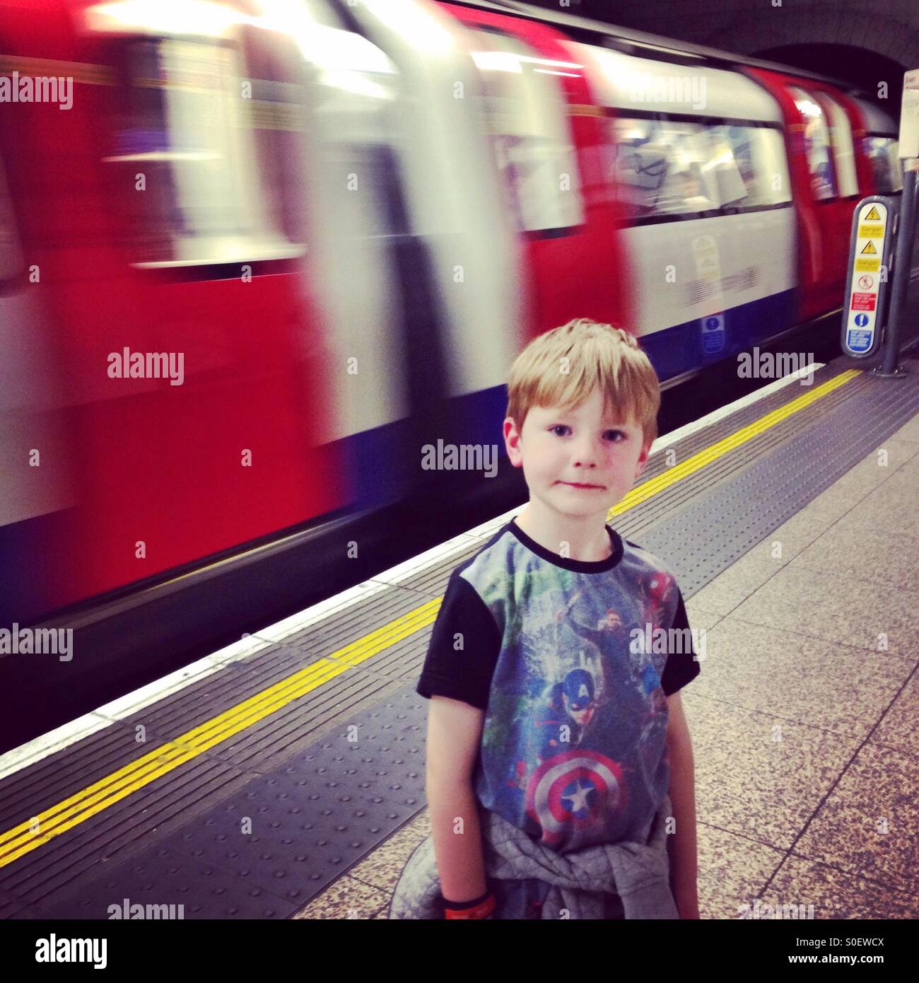 Boy standing next to moving tube train Stock Photo - Alamy