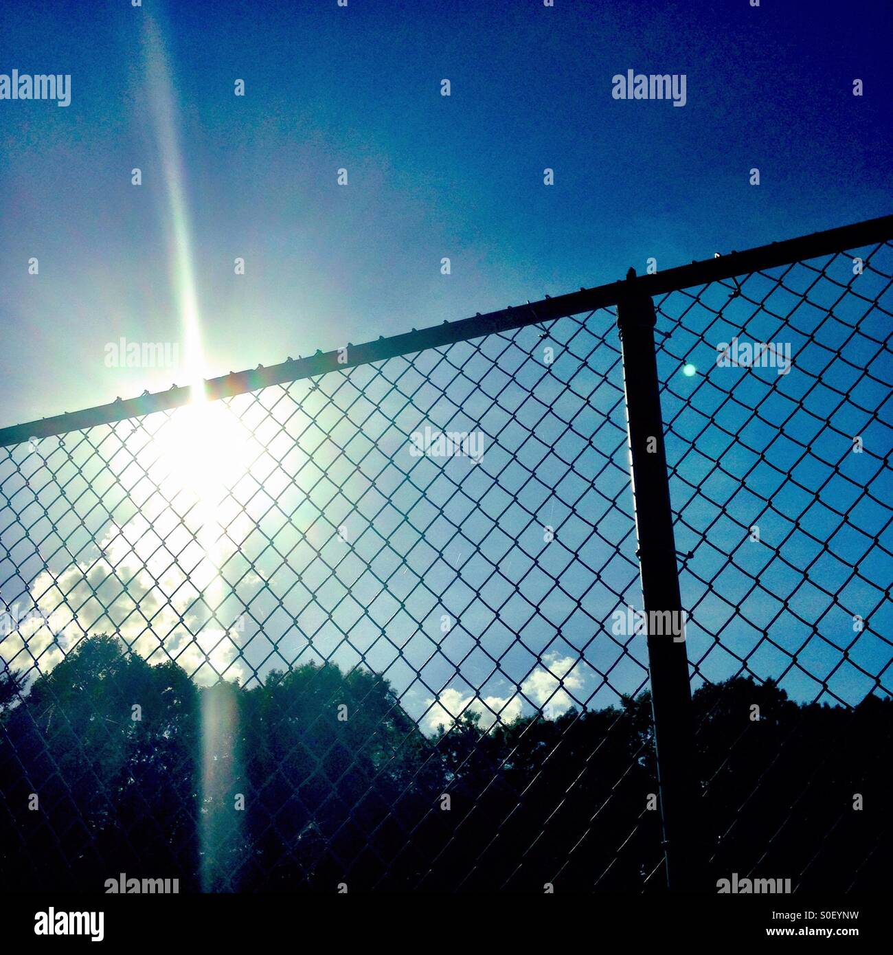 Sun flare over a fence Stock Photo - Alamy