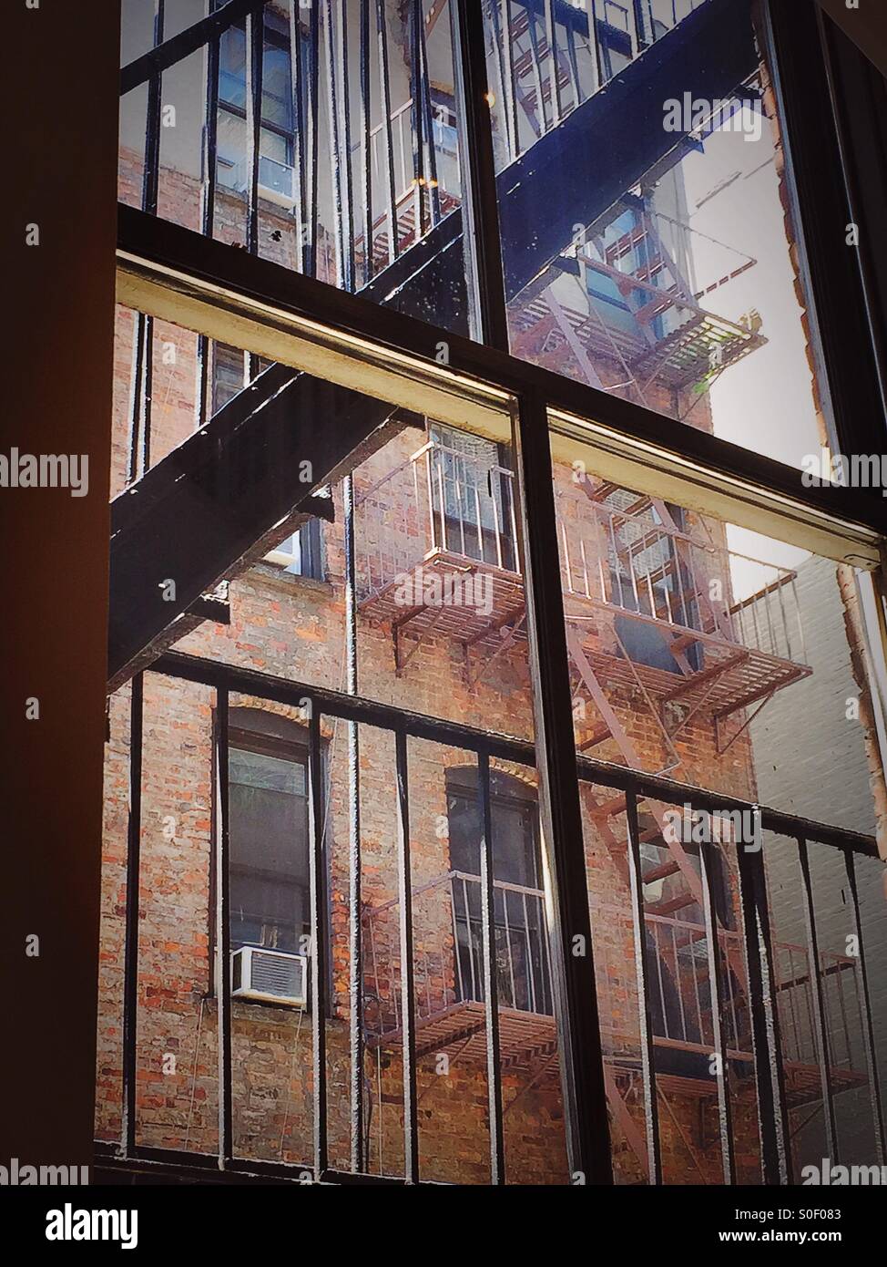 Fire escape through window SoHo NYC Stock Photo - Alamy