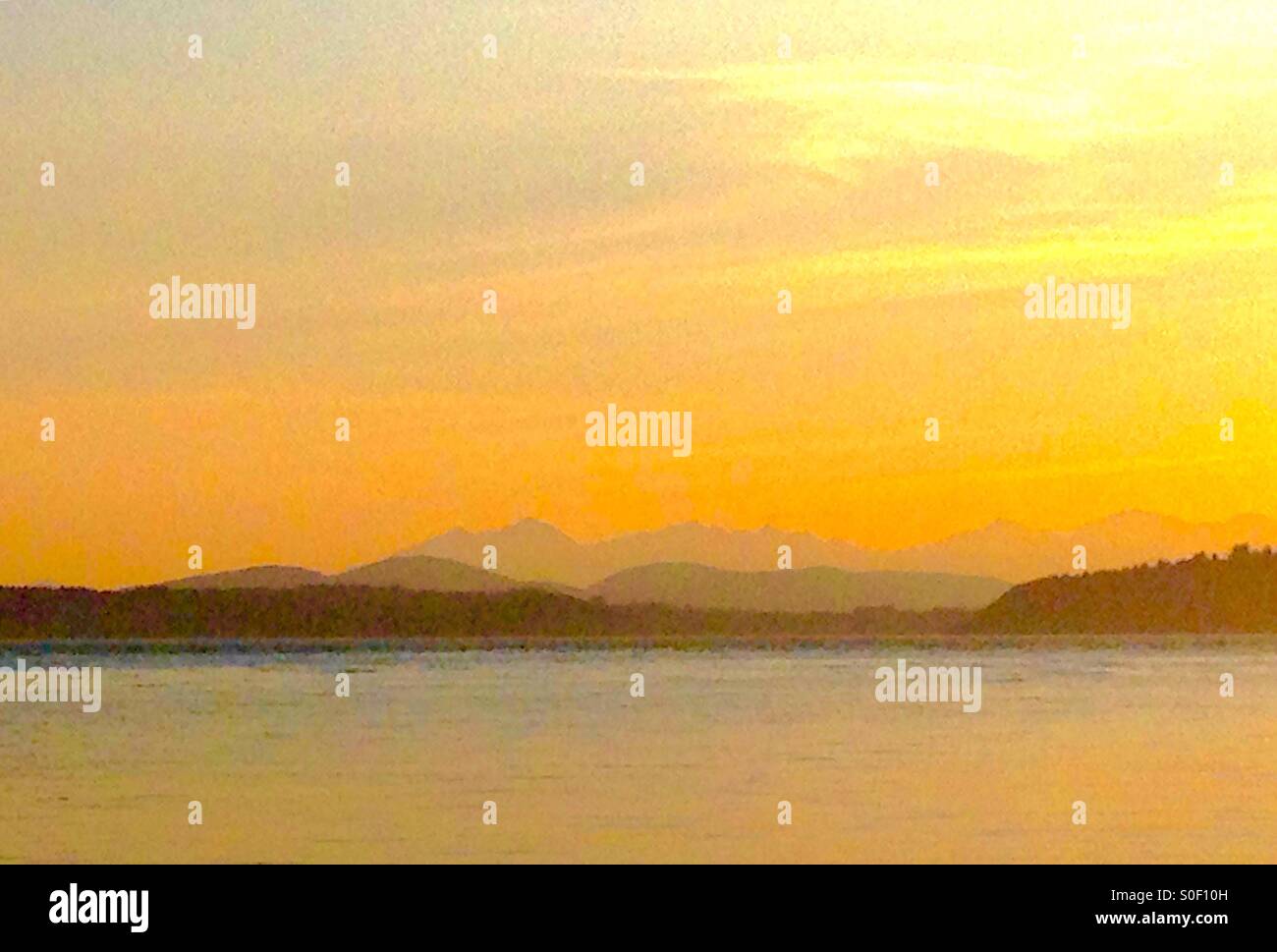 Sun setting over the Olympic mountains as viewed from beach Drive in ...