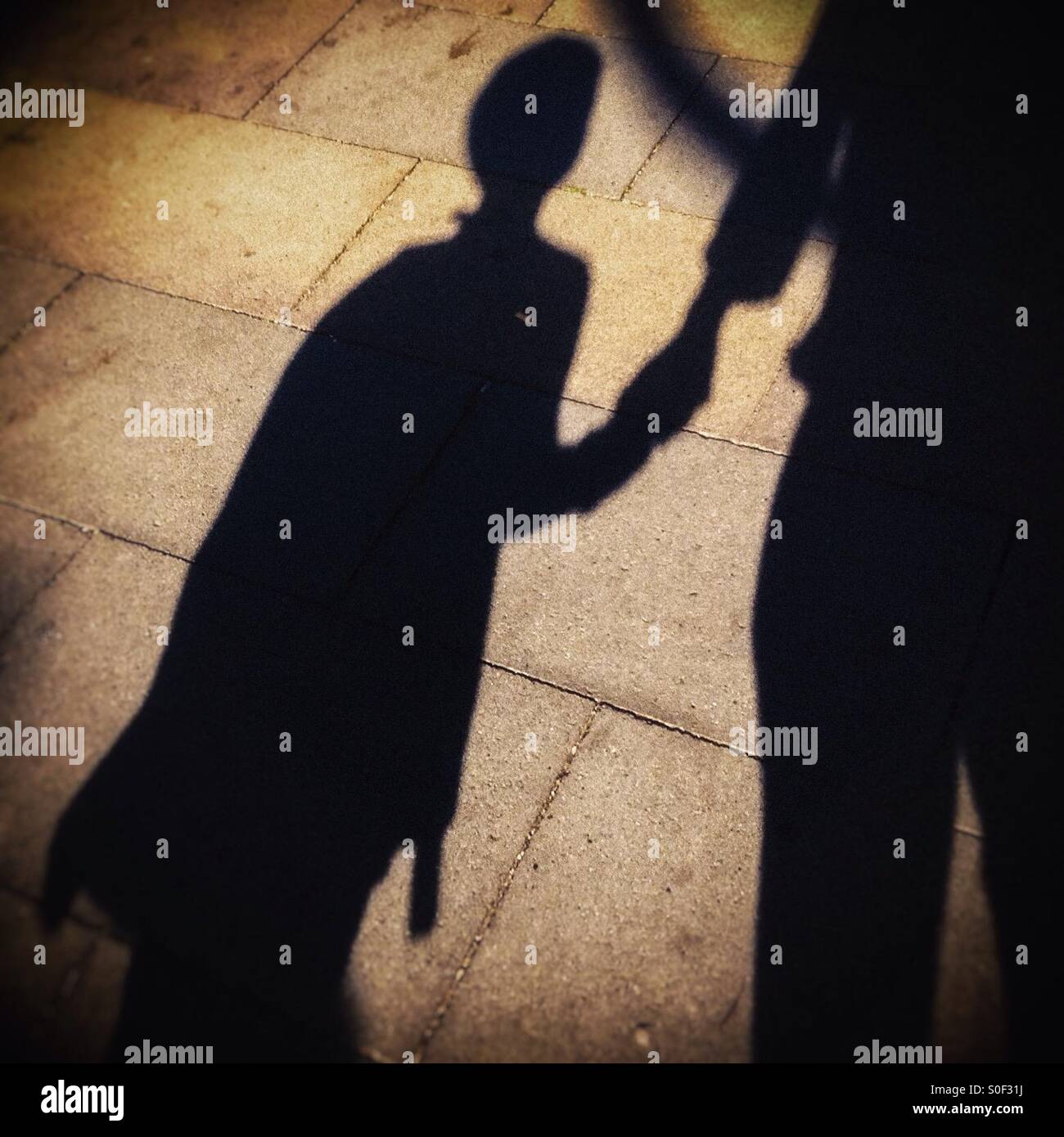 Shadow of a mother and her child walking together on the street in ...