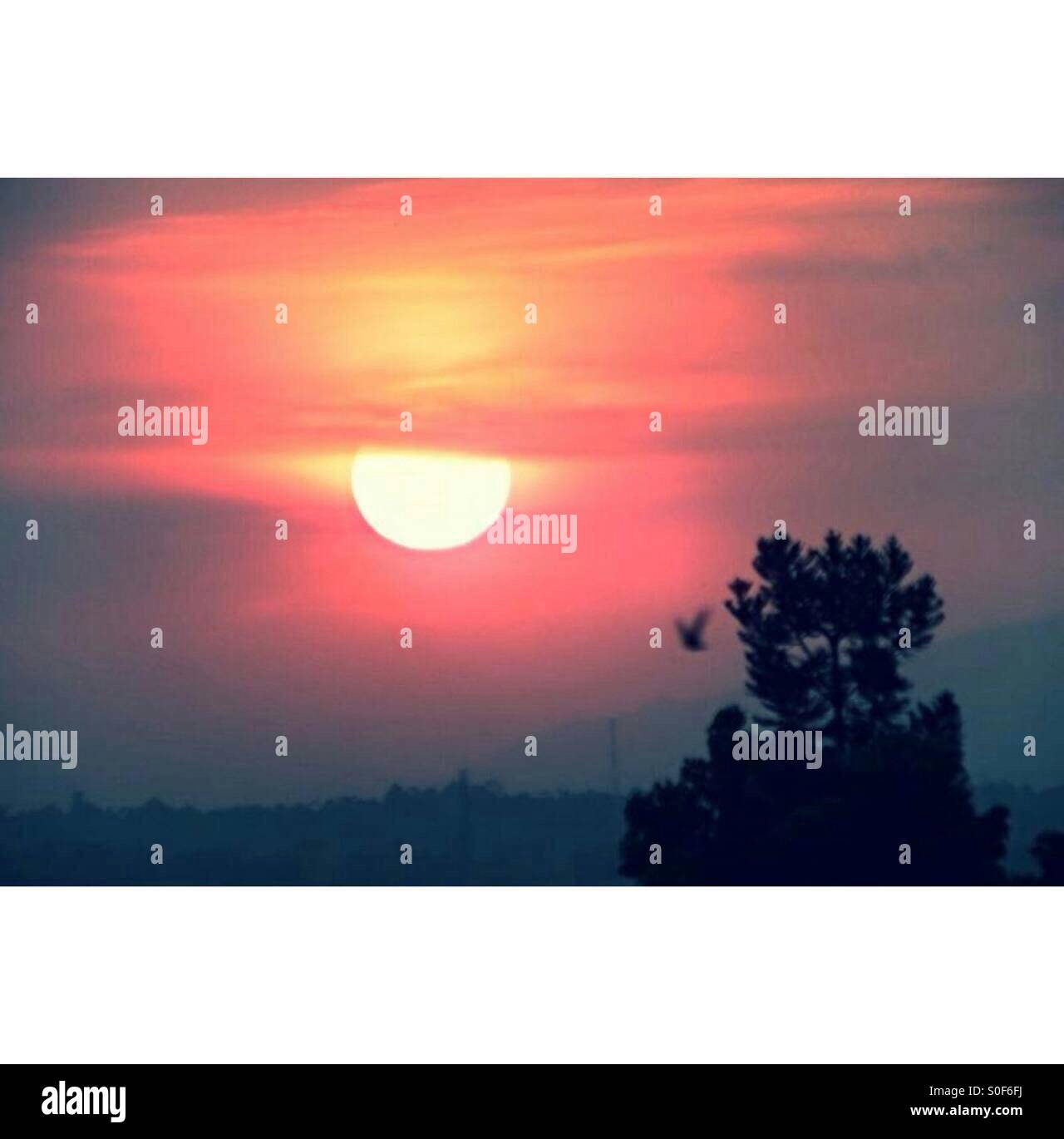 Half sun in orange sky Stock Photo - Alamy