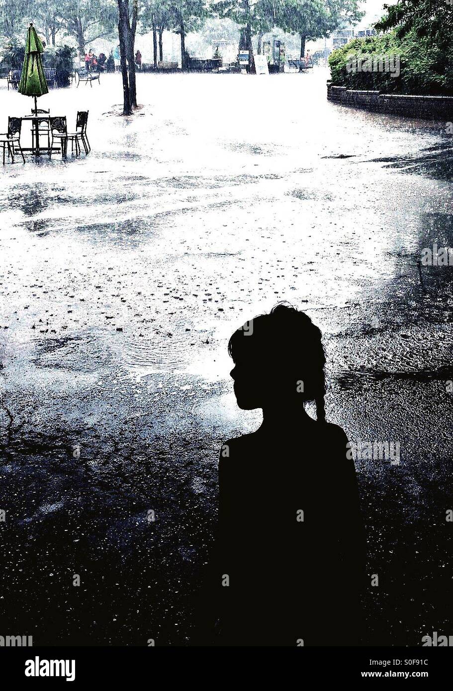 A silhouette of a young child looking at a storm after she escapes the ...