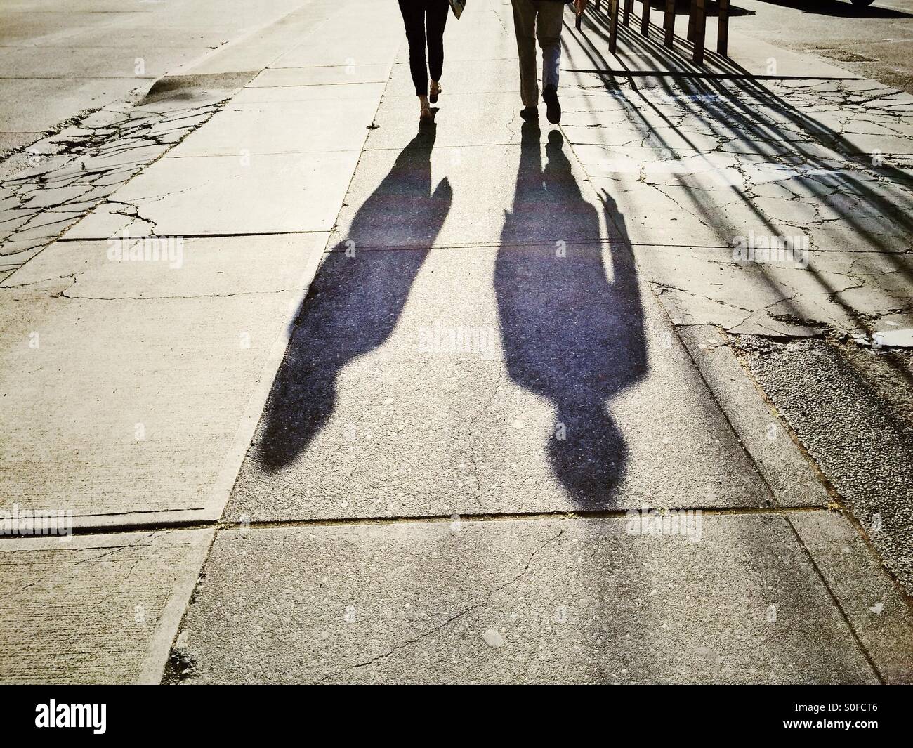 long shadows of man and woman on the pavement Stock Photo - Alamy
