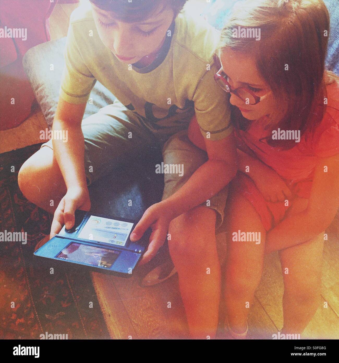 Brother and sister playing on Nintendo 3DS Stock Photo - Alamy