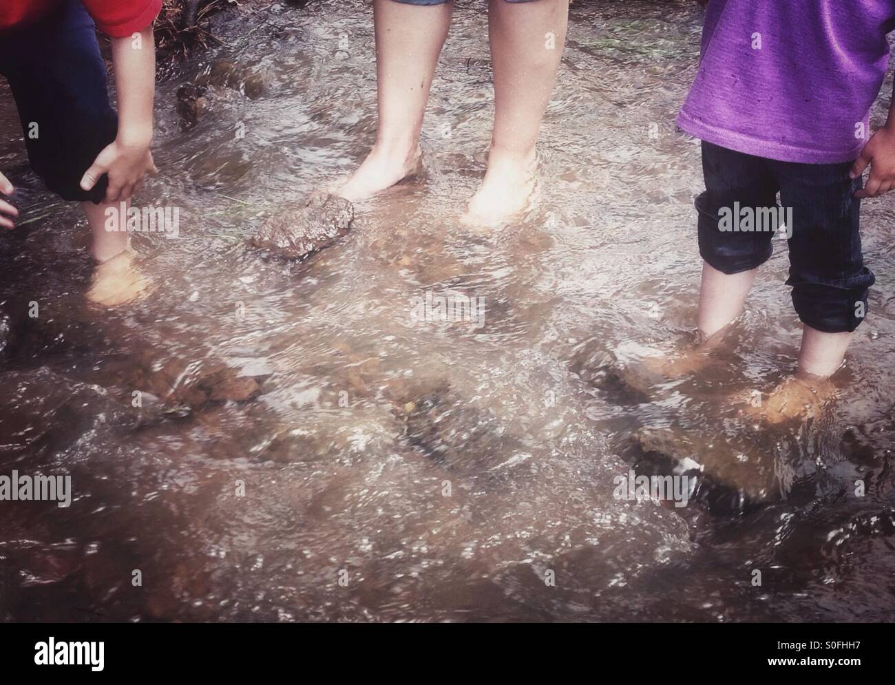 Young children wading in a creek in western Colorado Stock Photo - Alamy