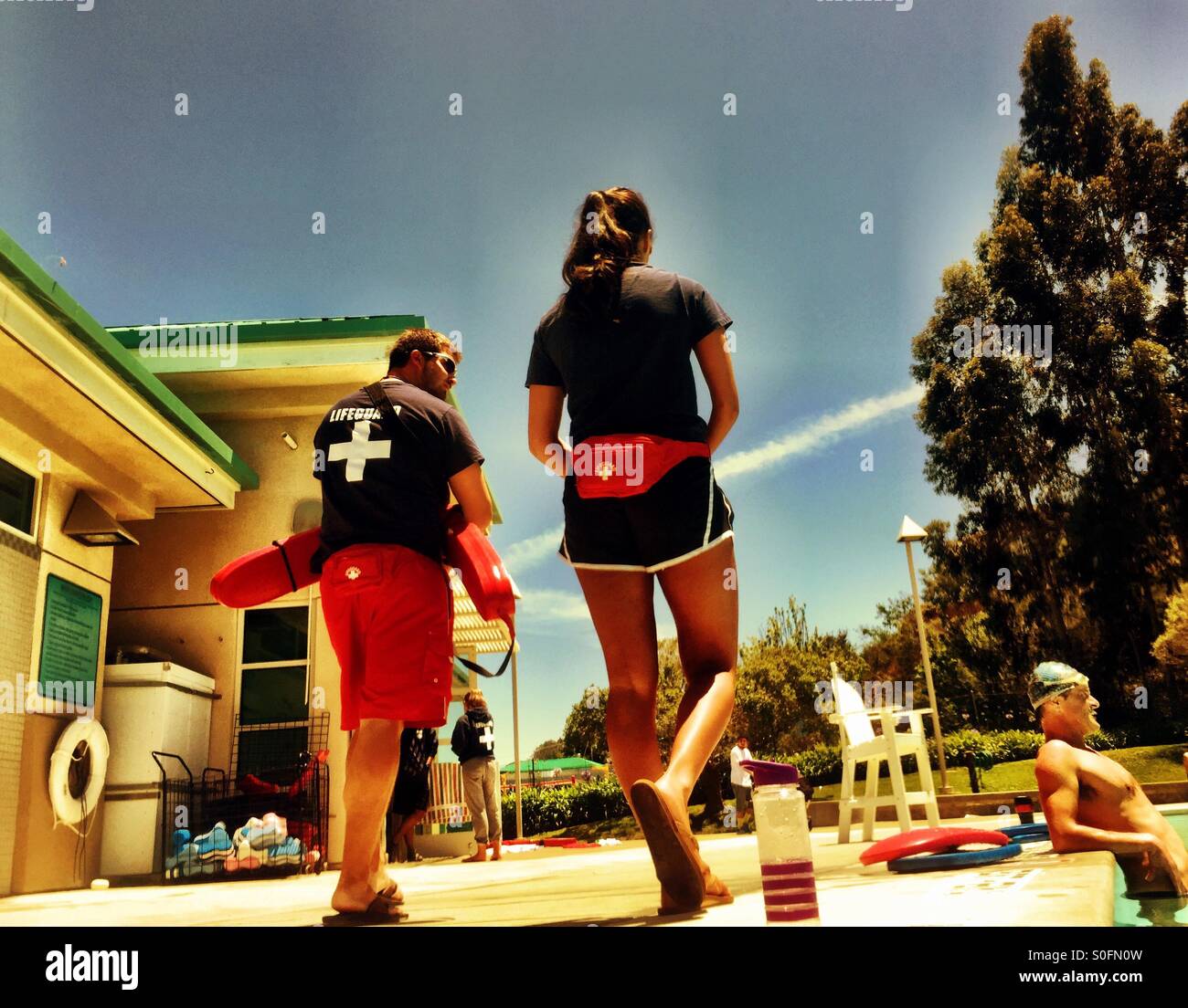 The swimming pool scene. Lifeguards, swimmers, a scene on the deck of a ...