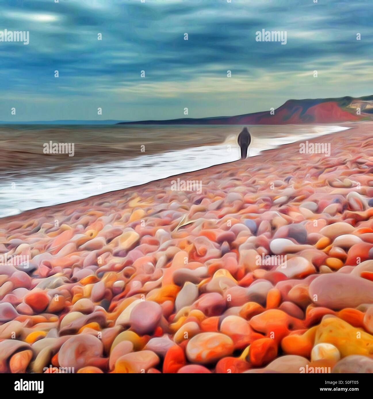 Figure on a stoney beach in Devon Stock Photo - Alamy