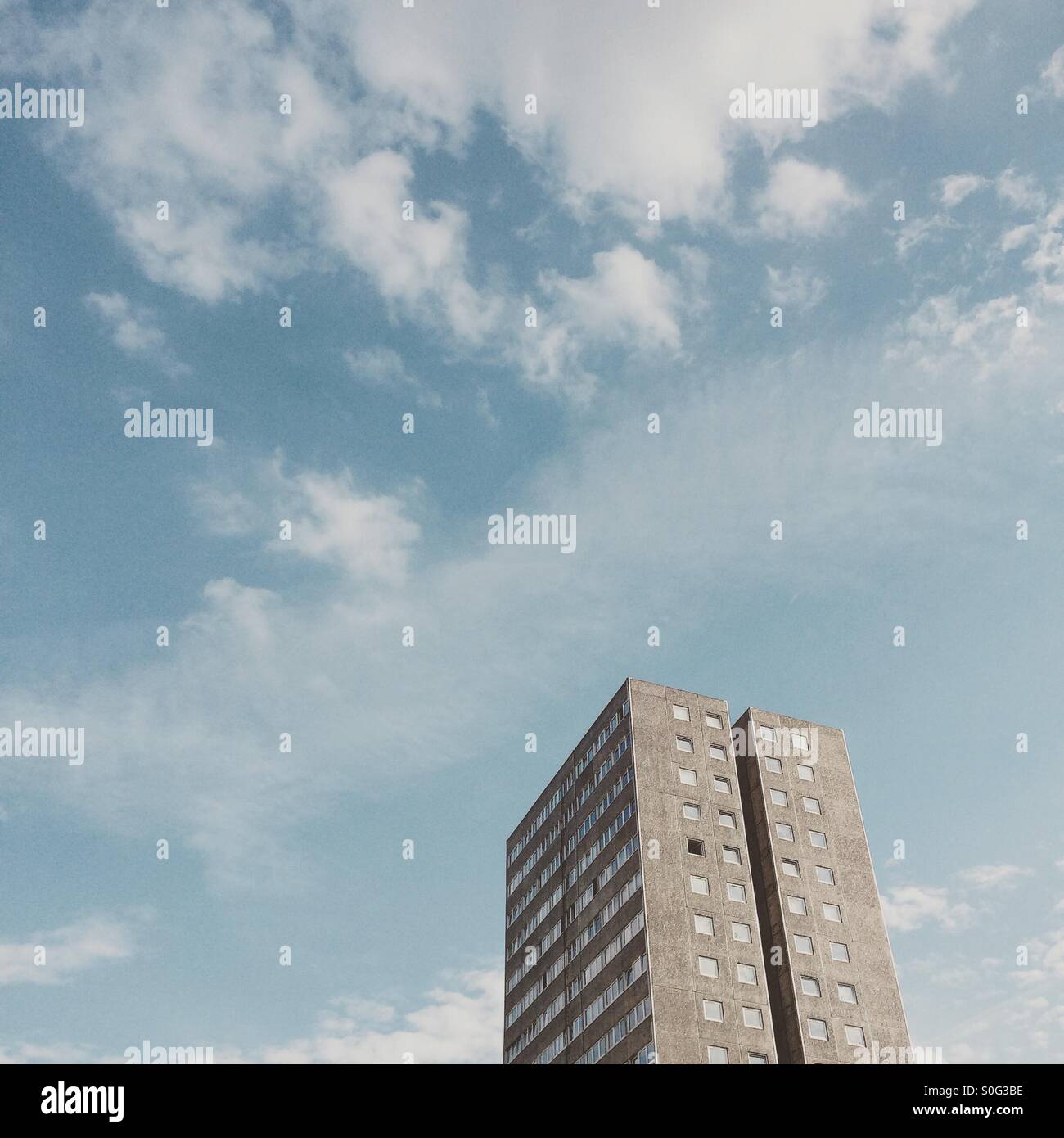 A single tower block against a blue sky Stock Photo - Alamy