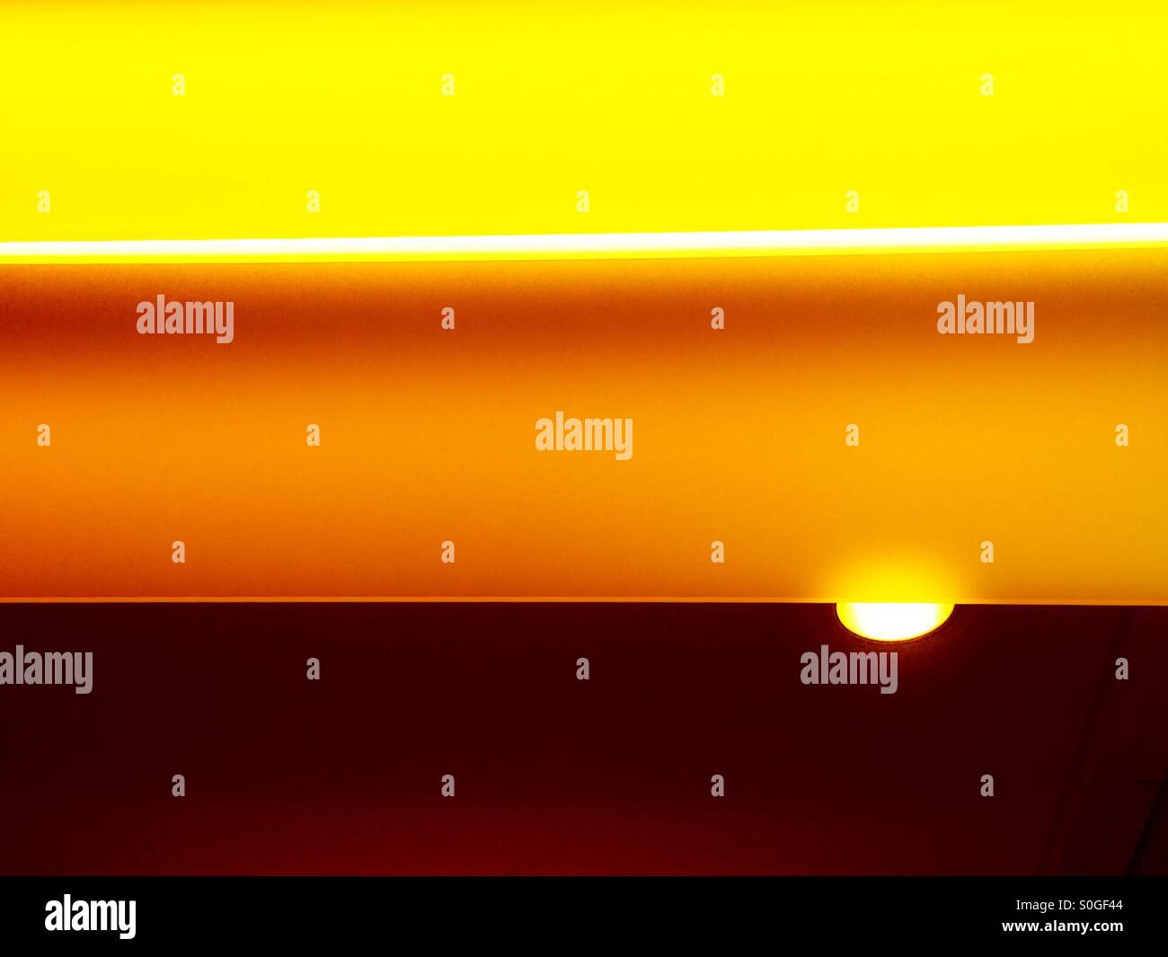 A single spotlight illuminating a yellow perspex case Stock Photo - Alamy