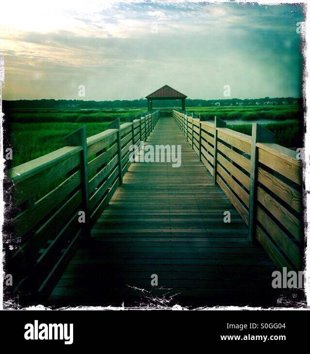 Walkway to dock at sunset Stock Photo - Alamy