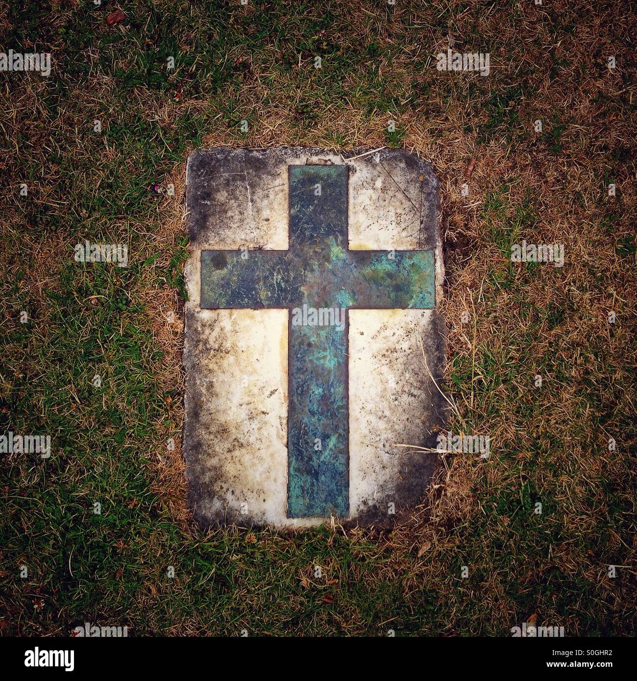 Brass weathered cross on ground Stock Photo - Alamy