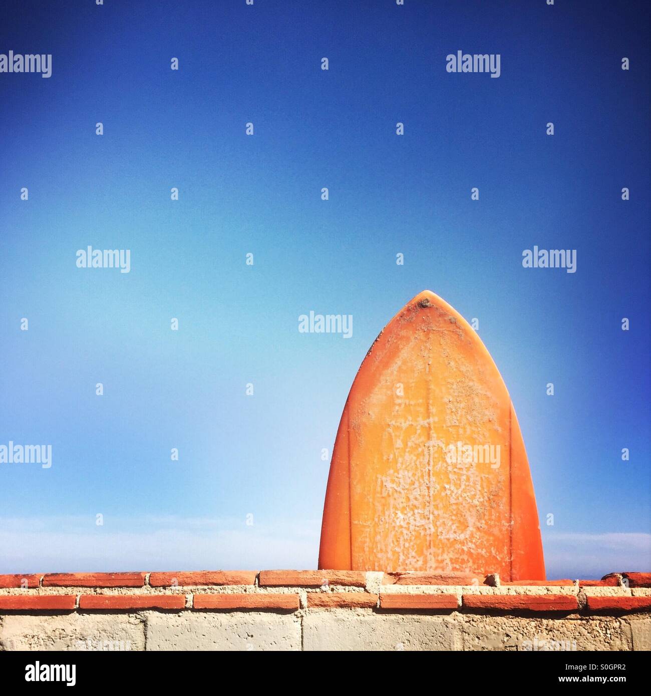 An orange surfboard on a wall. Malibu California USA Stock Photo - Alamy