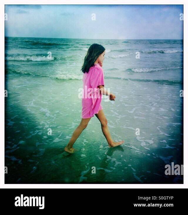 Girl walking on beach Stock Photo - Alamy