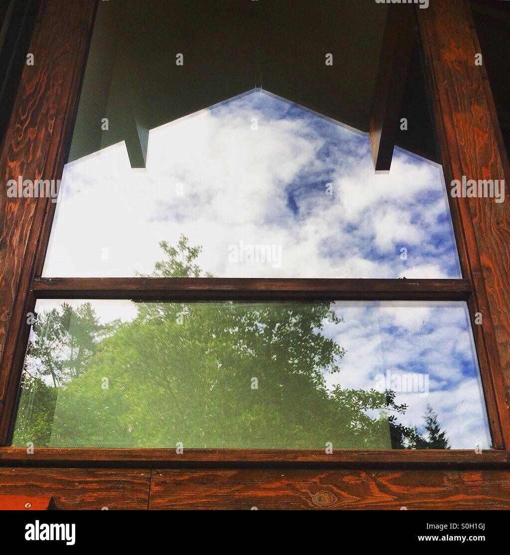 Reflection of trees and sky on a forest cabin window Stock Photo - Alamy