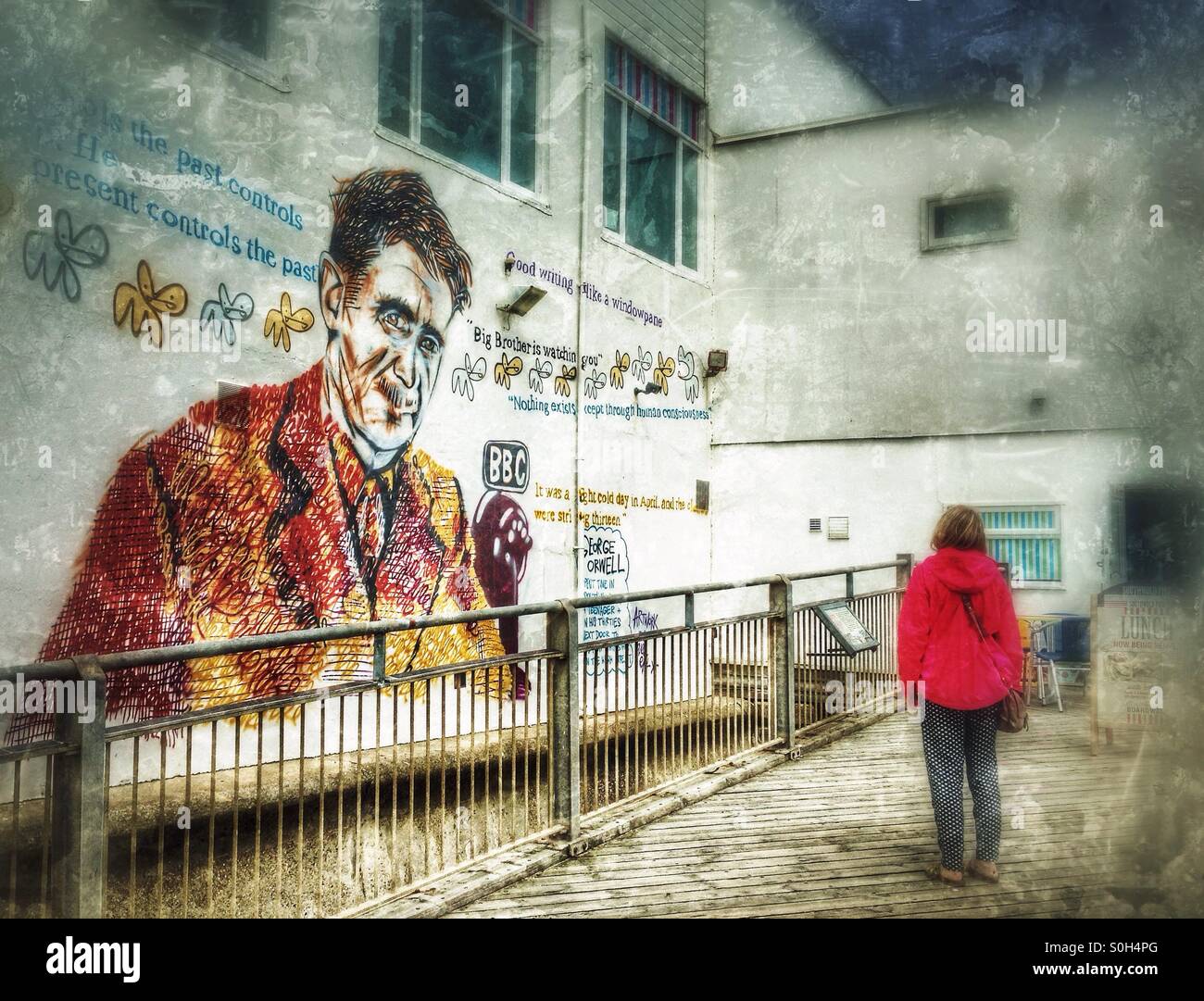 Woman viewing artwork inspired by George Orwell on Southwold Pier, Suffolk, England. The work ...