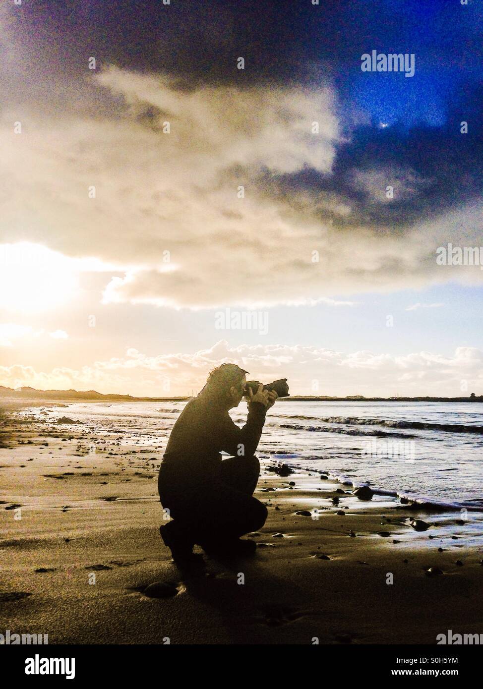 Photographer capturing sunset at Harlech beach Stock Photo - Alamy