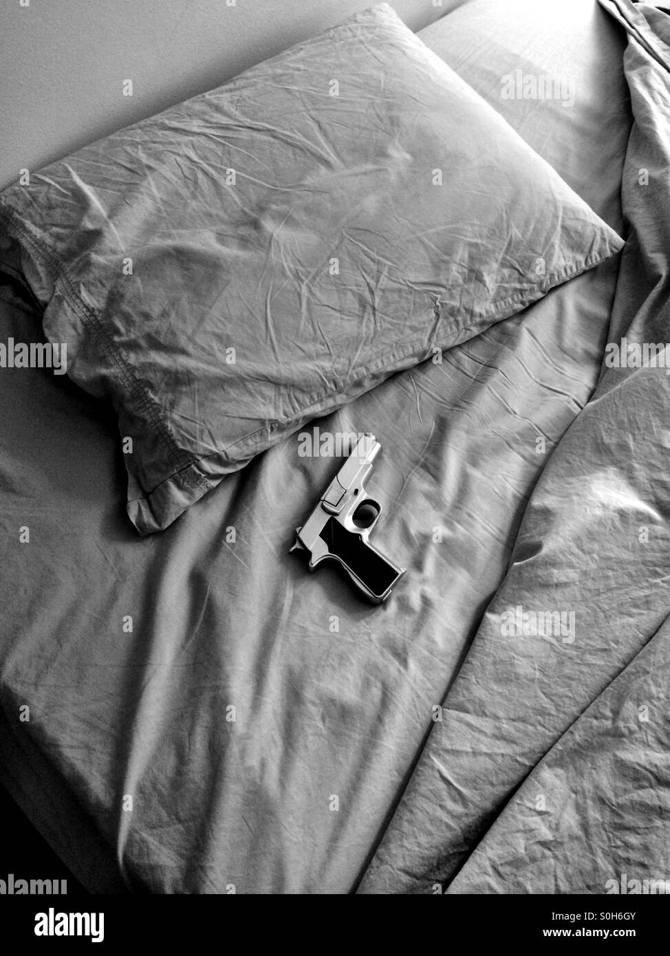 Gun in unmade bed Stock Photo - Alamy