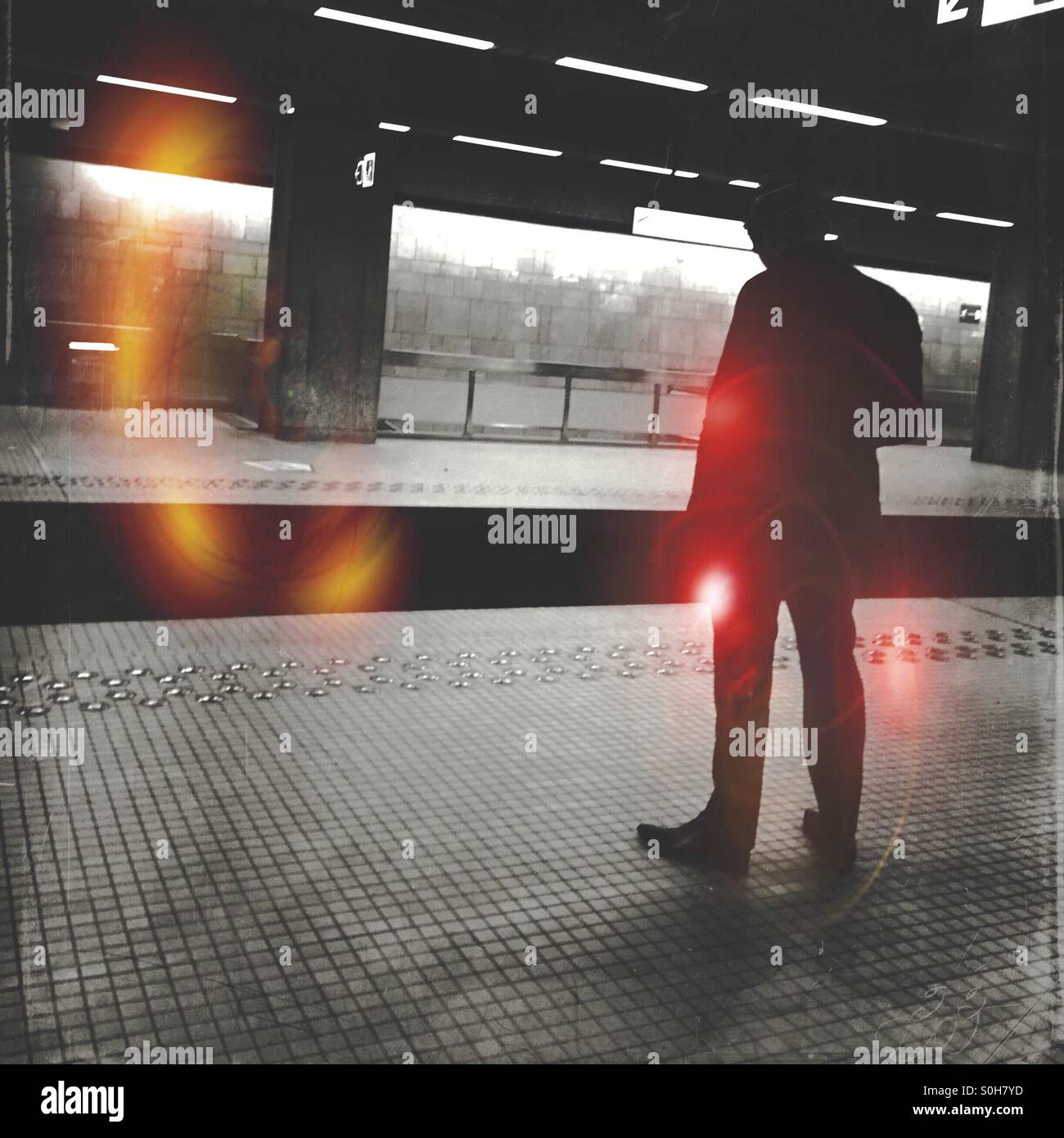 Lights. Man alone standing in a subway station Stock Photo - Alamy