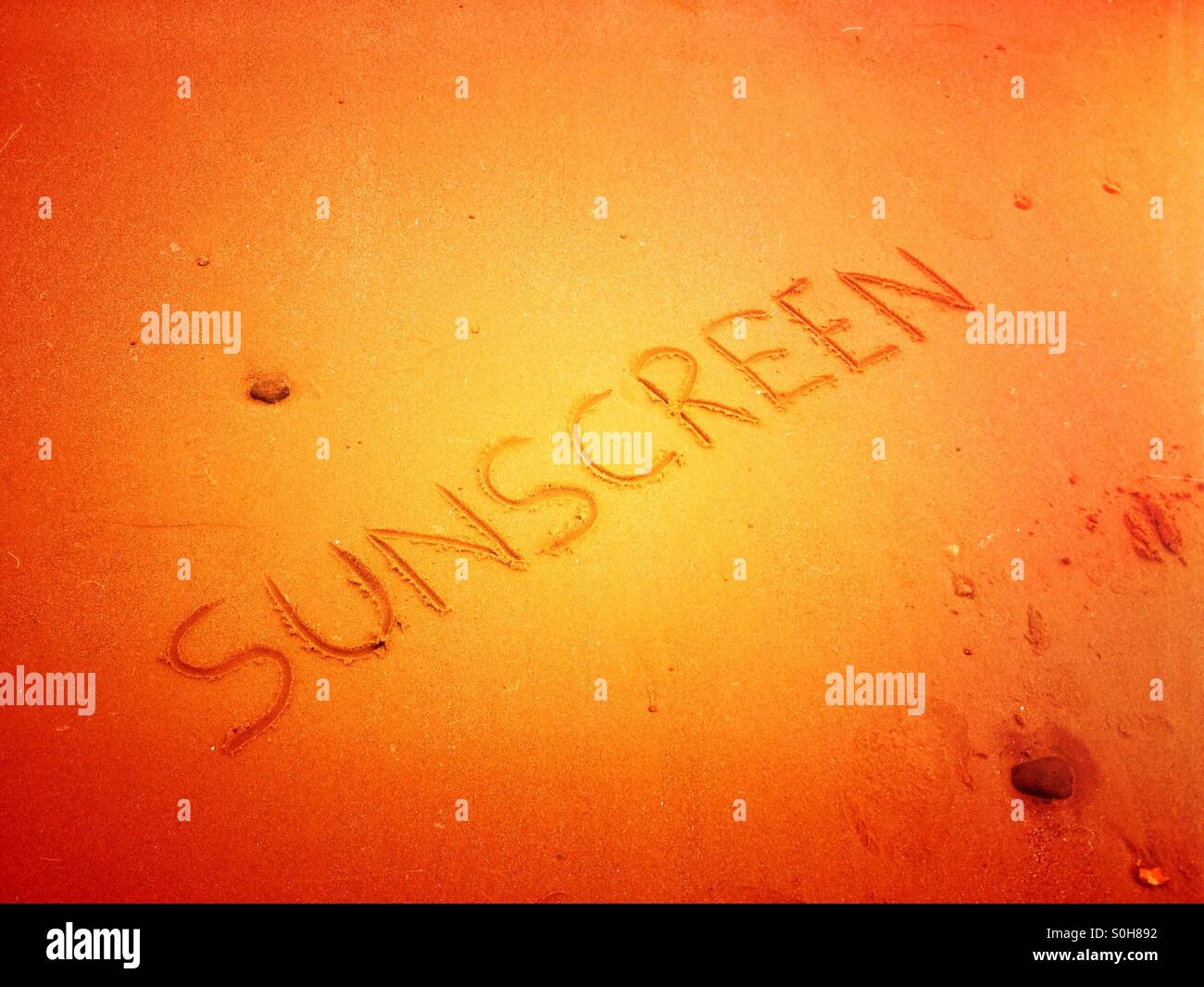 Sunscreen wrote in sand Stock Photo - Alamy