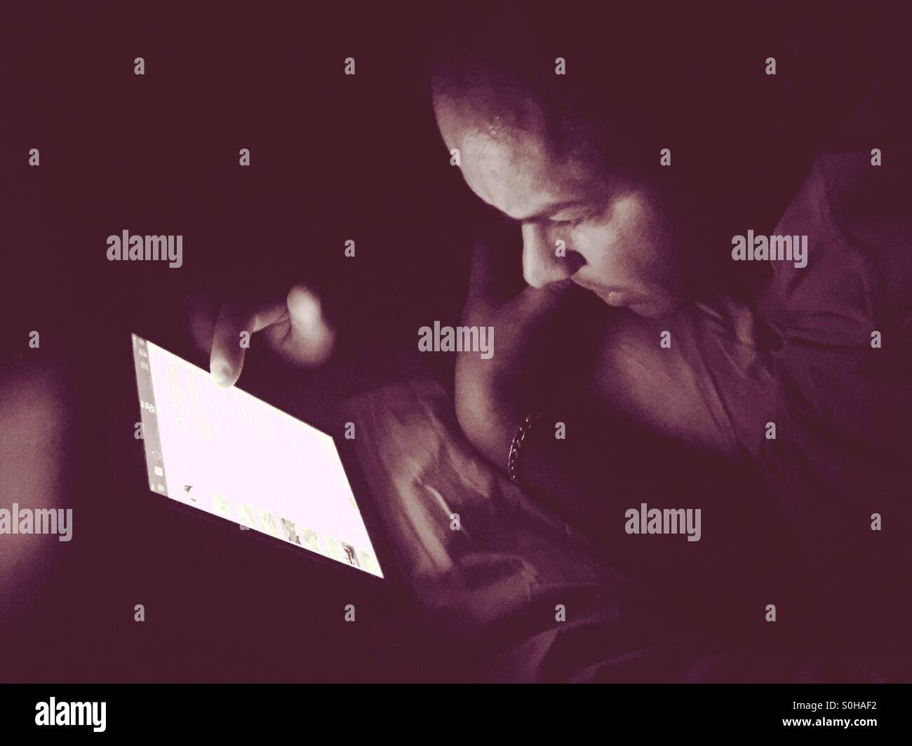 Man looking his ipad at night Stock Photo - Alamy