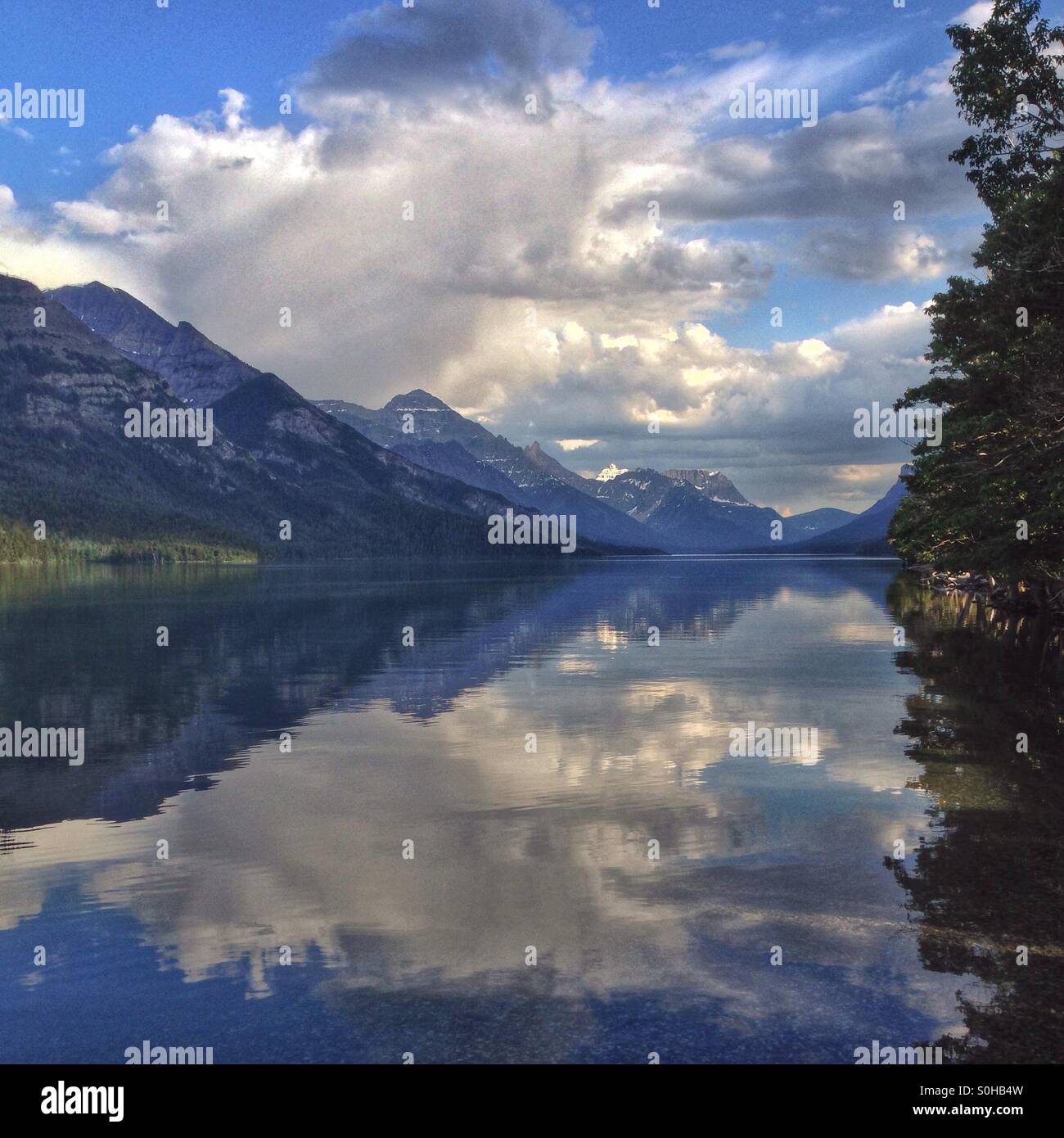 Reflection of mountains and sunset clouds over Waterton Lakes National ...