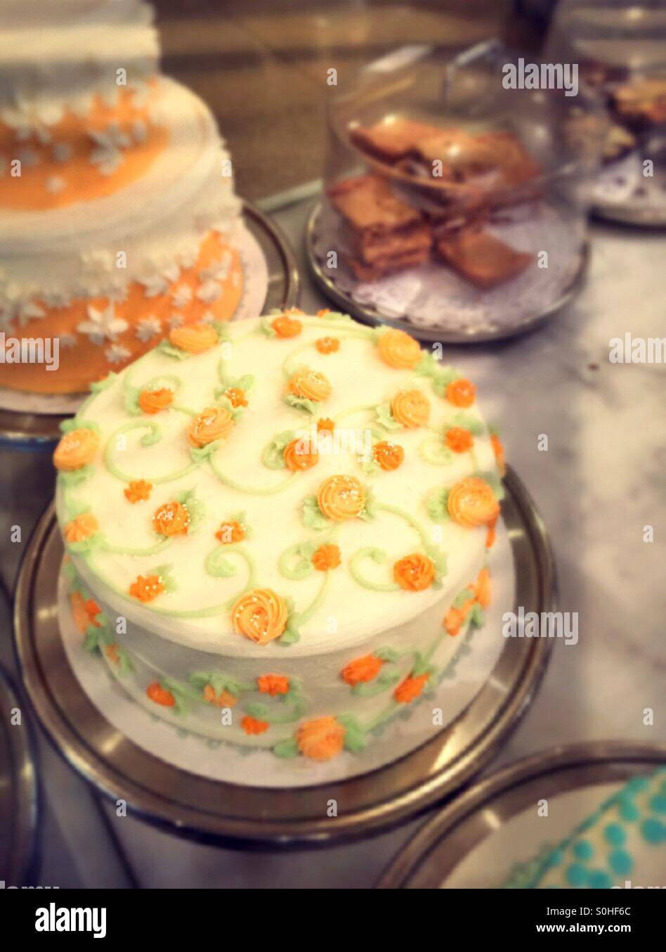 Brightly decorated layer cakes in the bakery display case Stock Photo ...