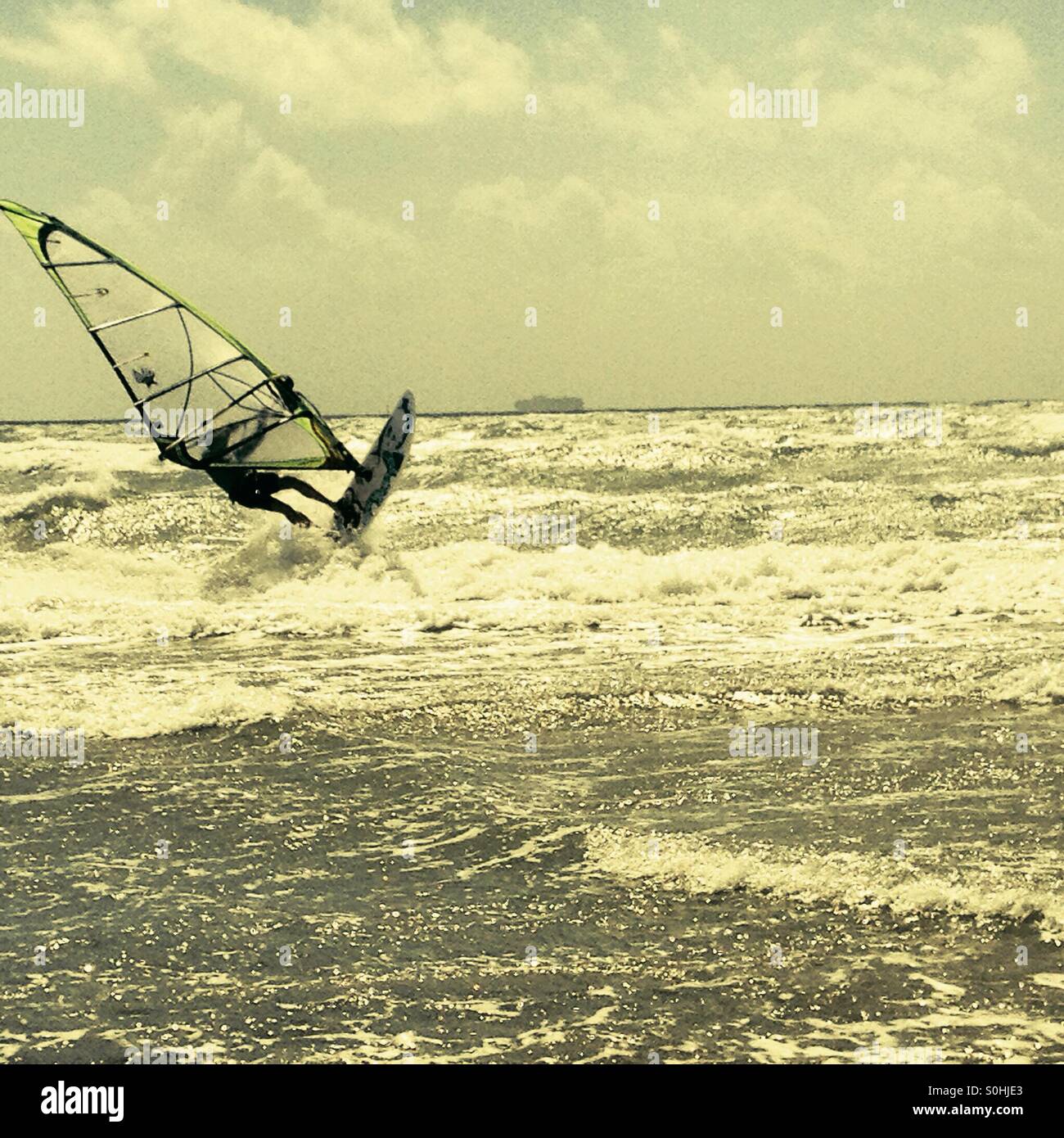 A windsurfer riding a wave at West Wittering beach in England, UK Stock ...