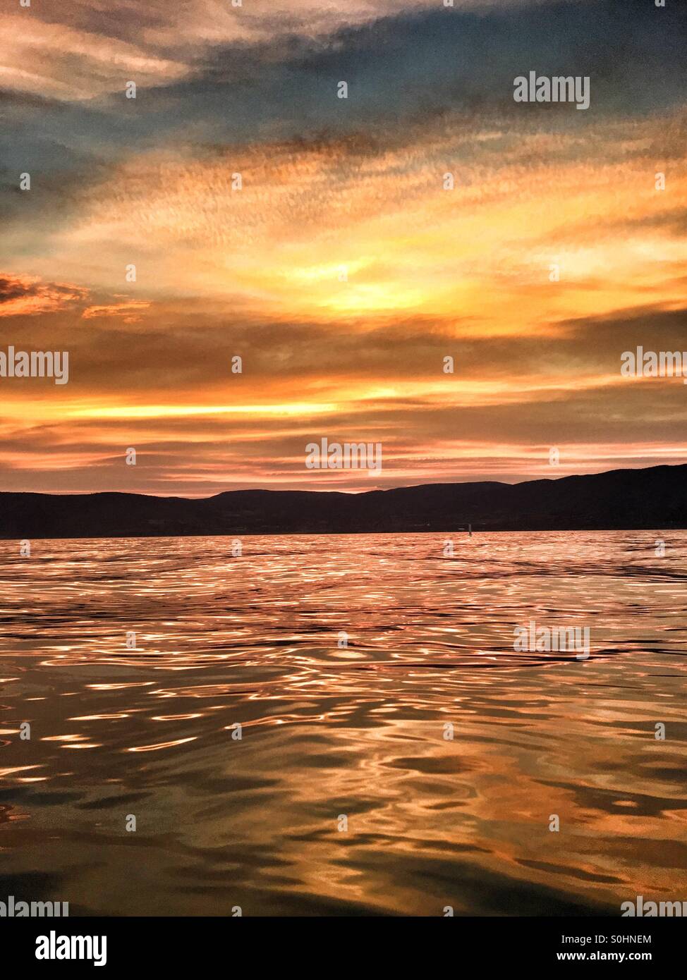 Golden sunset. The waters of the lake shimmer and shine as the setting ...