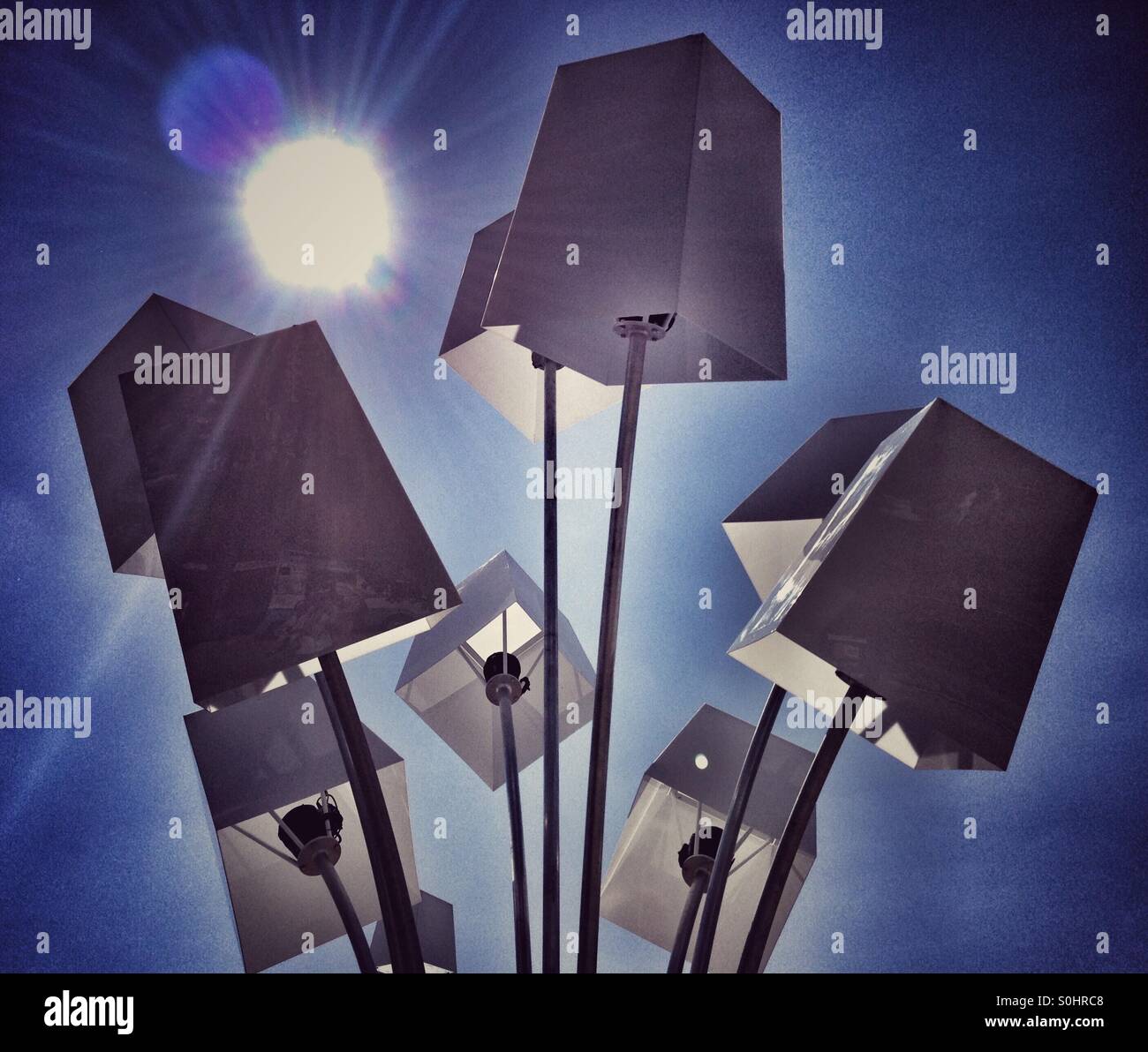 Street light lamp shades against blue sky with streaming sunlight Stock ...