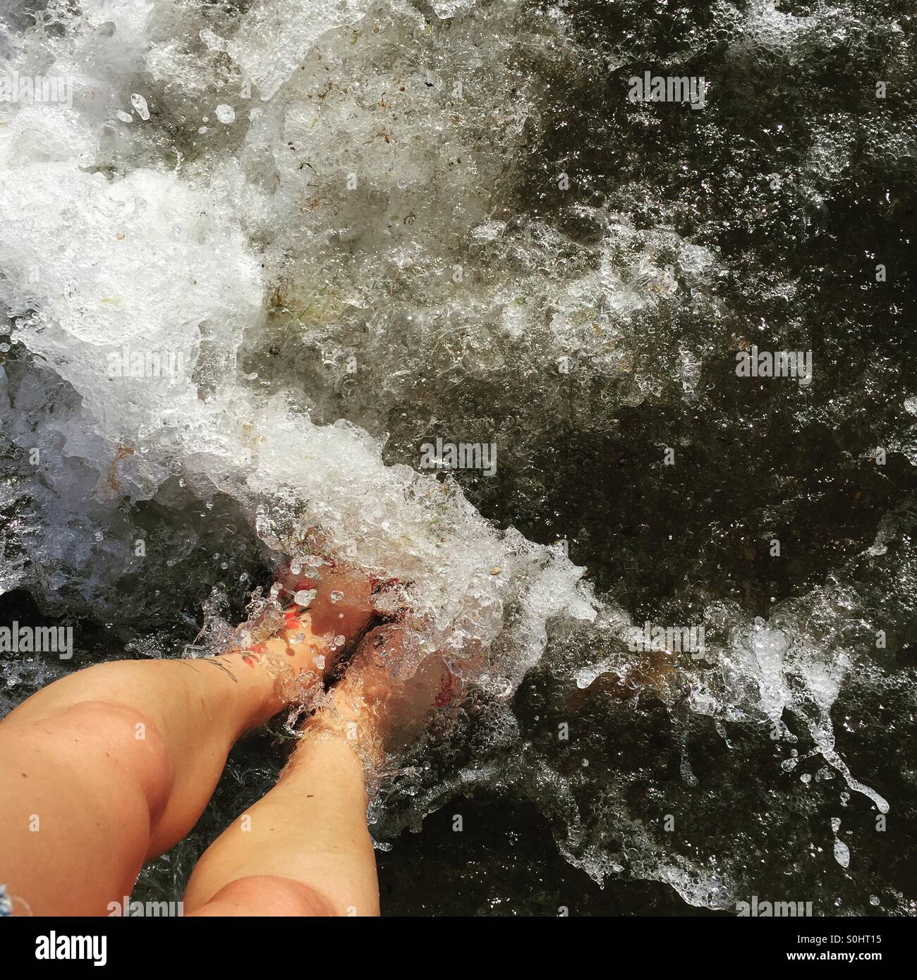 Paddling Feet washed over by a wave Stock Photo - Alamy